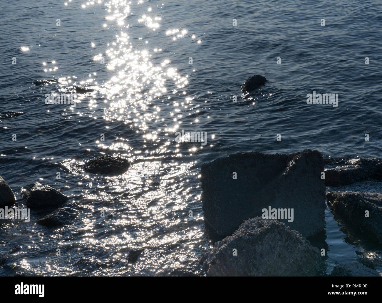 Sparkling light on the sea with rocks Stock Photo - Alamy
