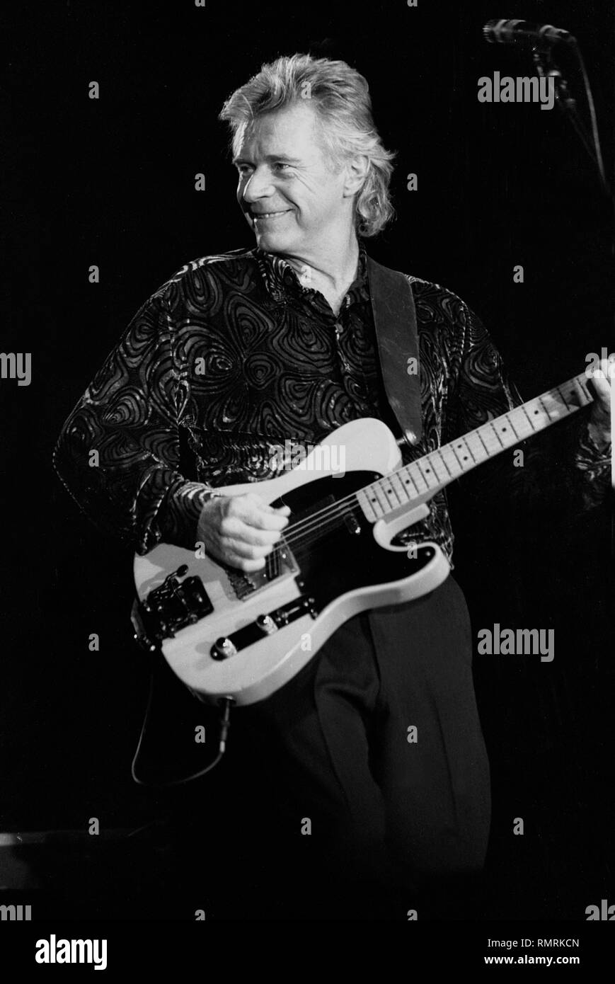Musician Dave Edmunds is shown performing on stage during a "live ...