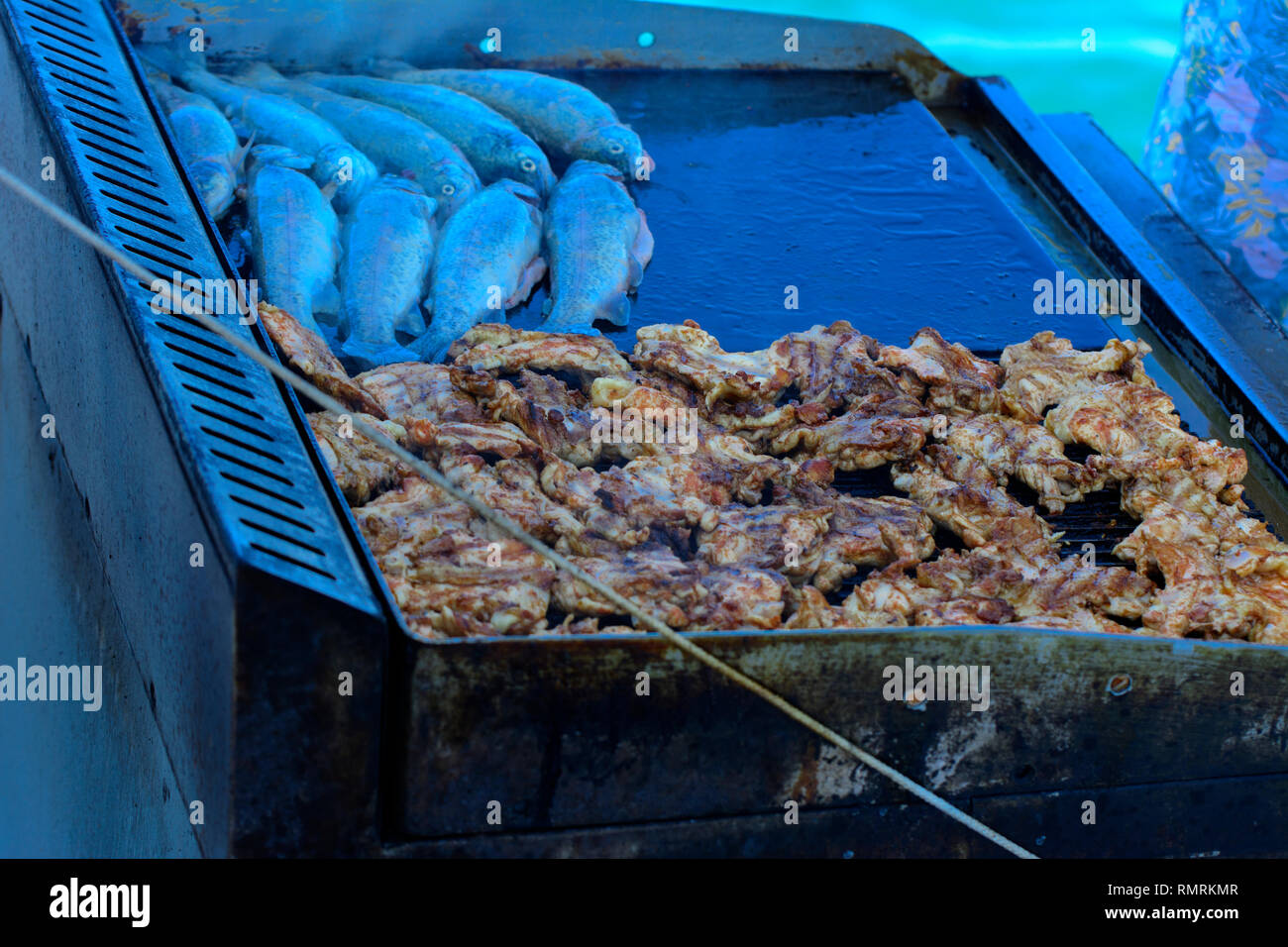 Beautifully cooked fried pieces of quail meat and whole trout fish on ...