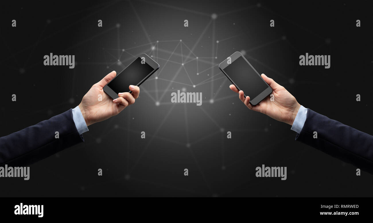 Close up of two hands holding smartphones to each other, wireless ...