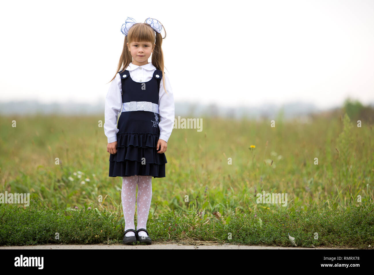 Full-length portrait of cute adorable serious thoughtful first grader ...