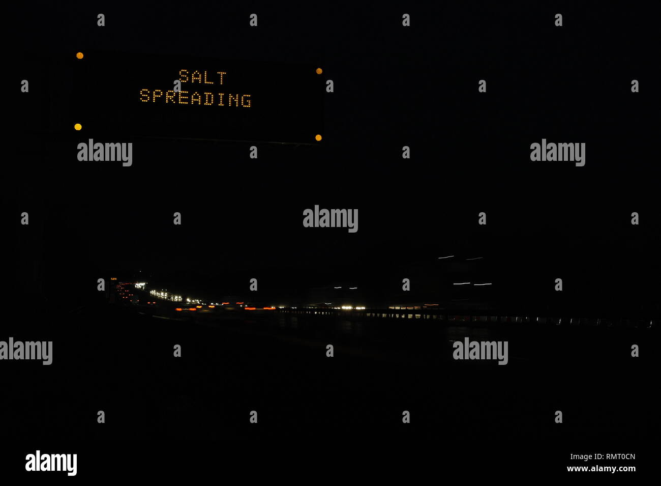 Salt spreading warning sign over motorway during cold winter driving ...