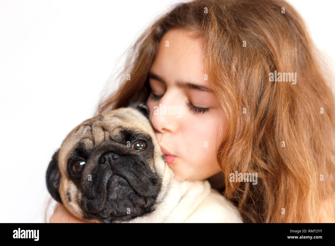 Cute teen girl hugging and kissing pug dog on white background Stock ...