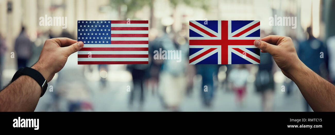 Two hands holding different flags, UK vs USA on politics arena over ...