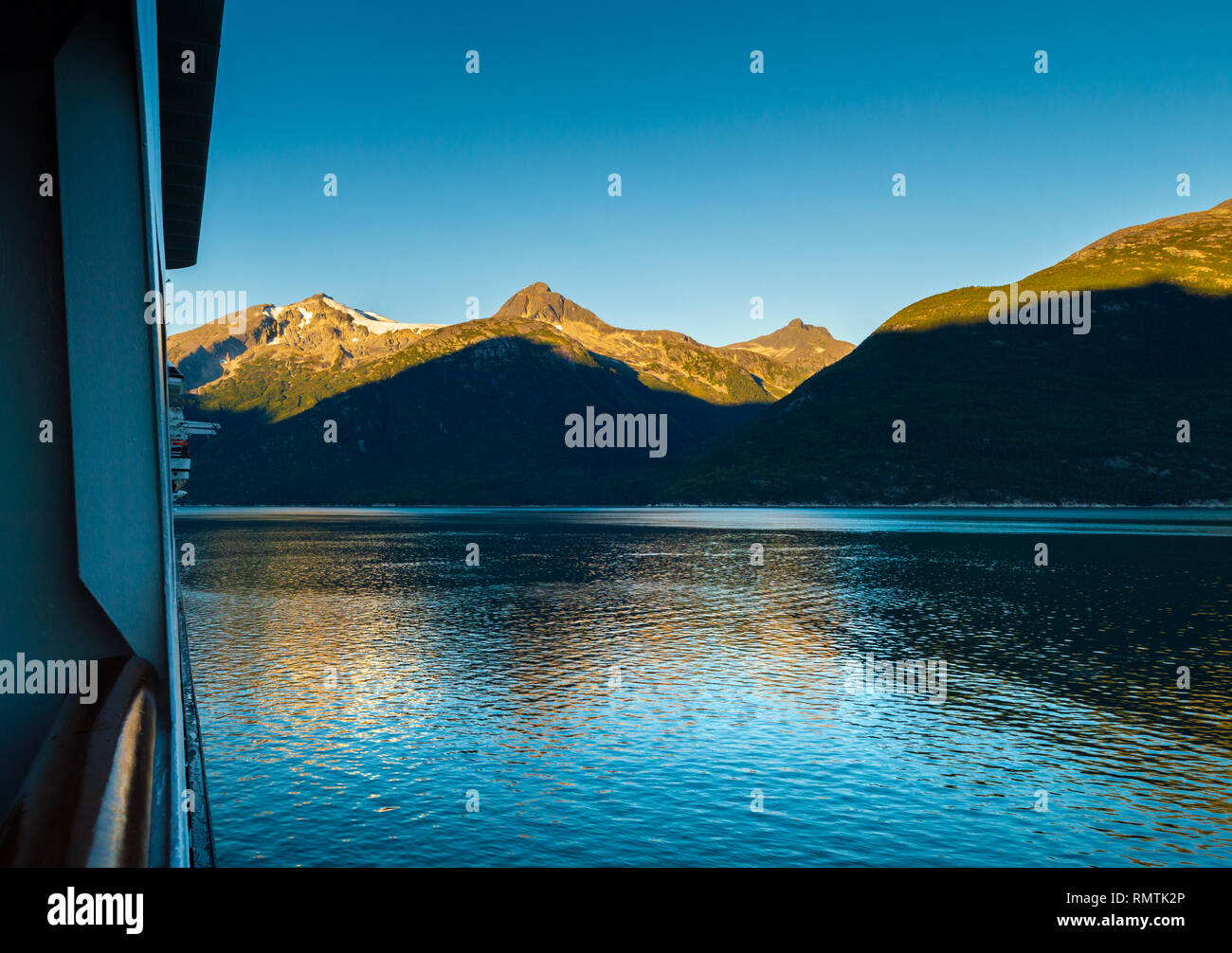 Early morning sunrise light on mountains, from outdoor promenade deck ...