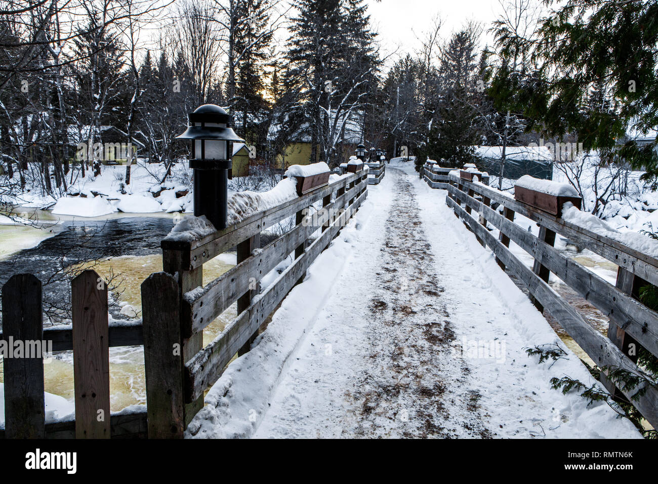 Pedestrian bridge with lanterns and snow-covered planter boxes ...