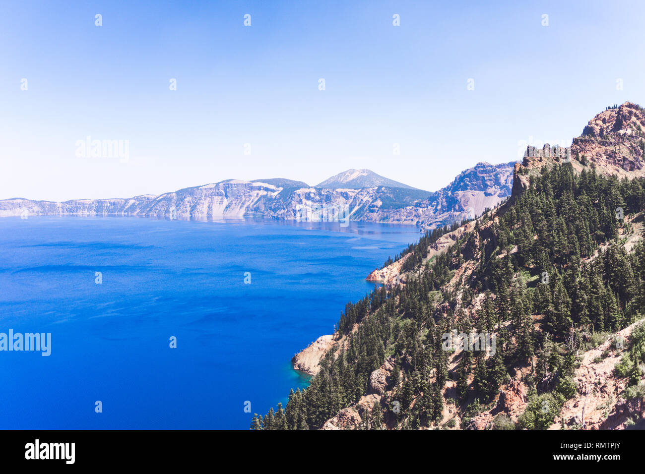 View of the sharp descending wall of the crater and the vibrant blue ...