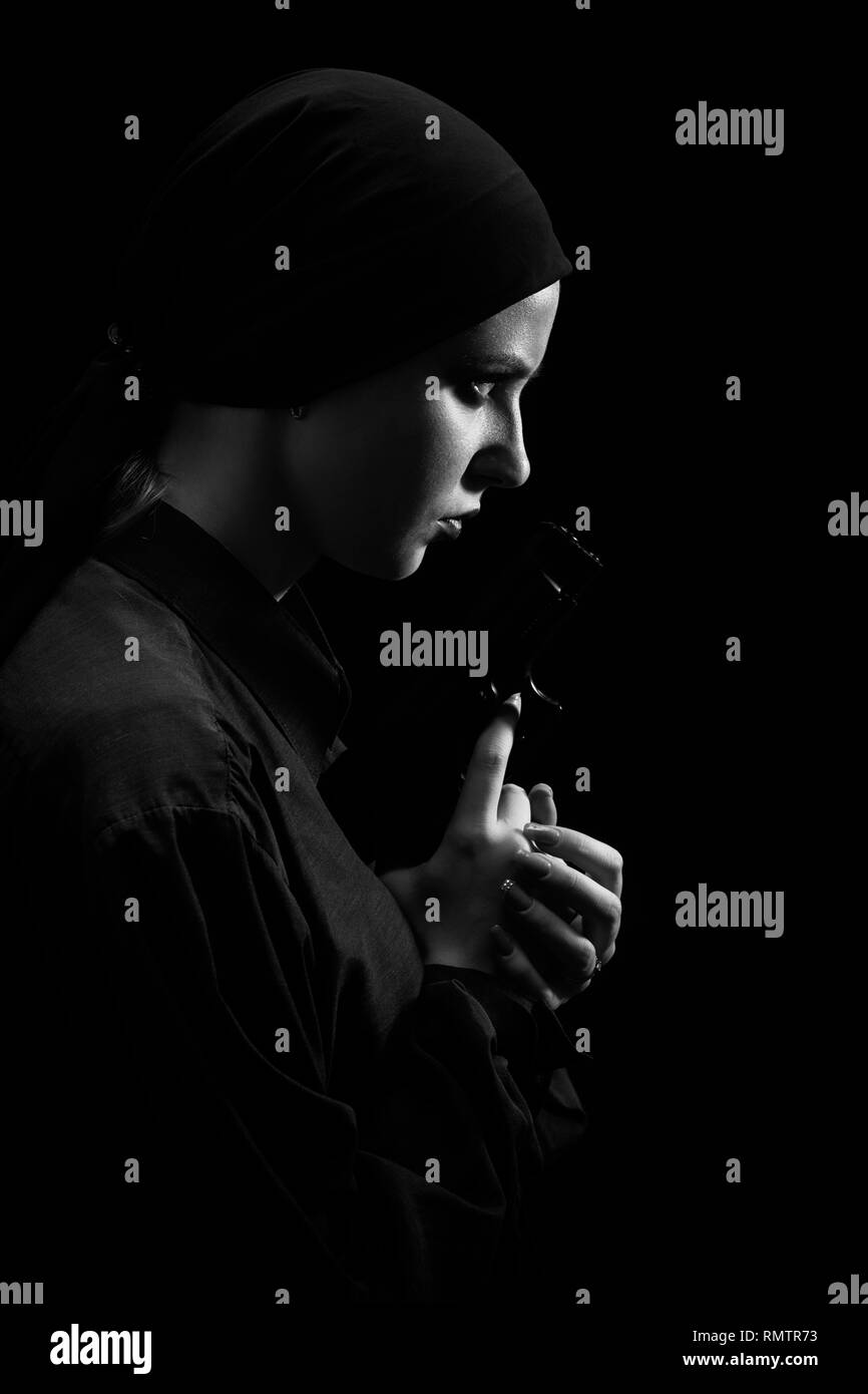 serious girl with gun profile on black background, side view Stock ...