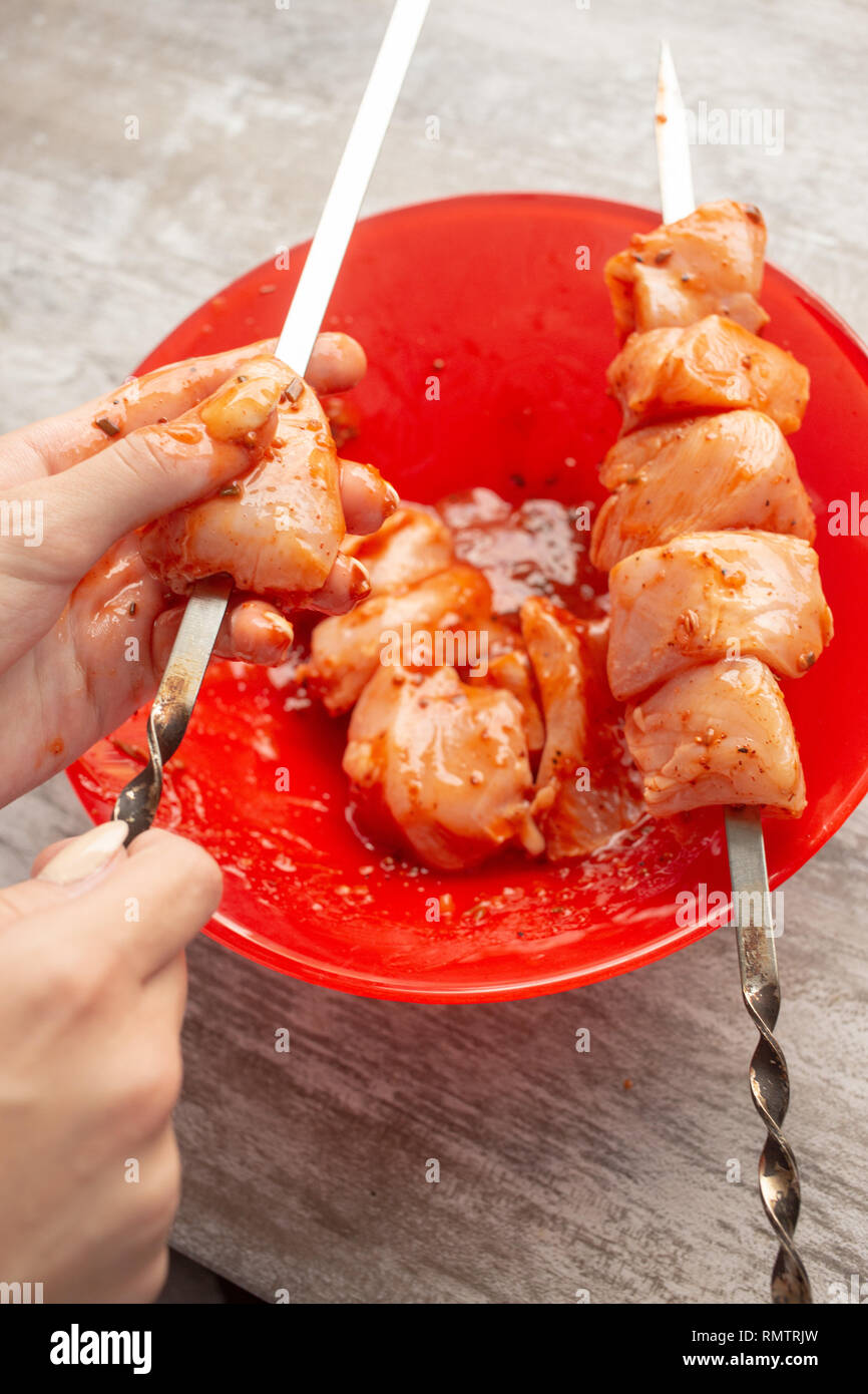 female hands skewer marinaded meat peaces on spit Stock Photo - Alamy