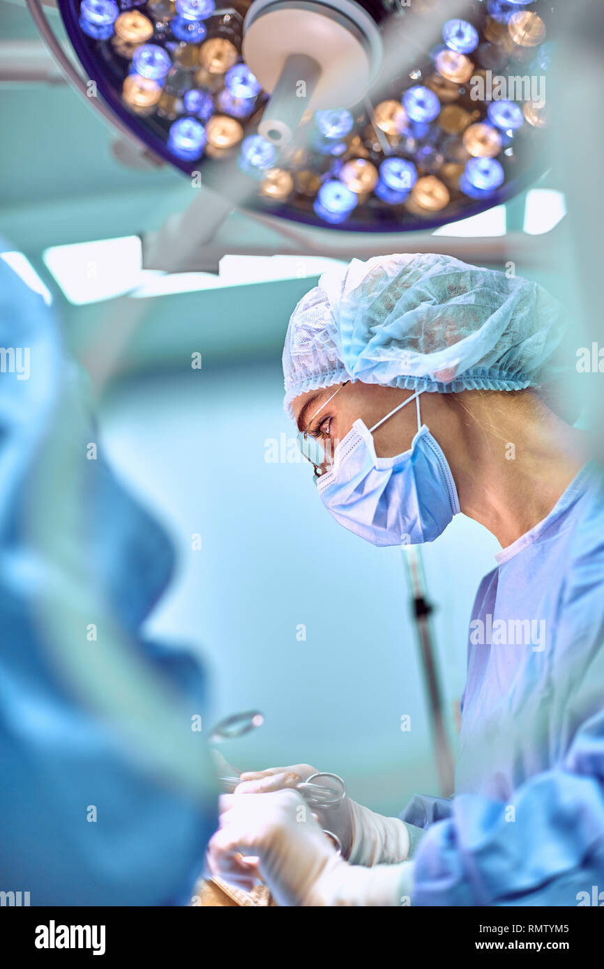 Close up portrait of young female surgeon doctor wearing protective ...