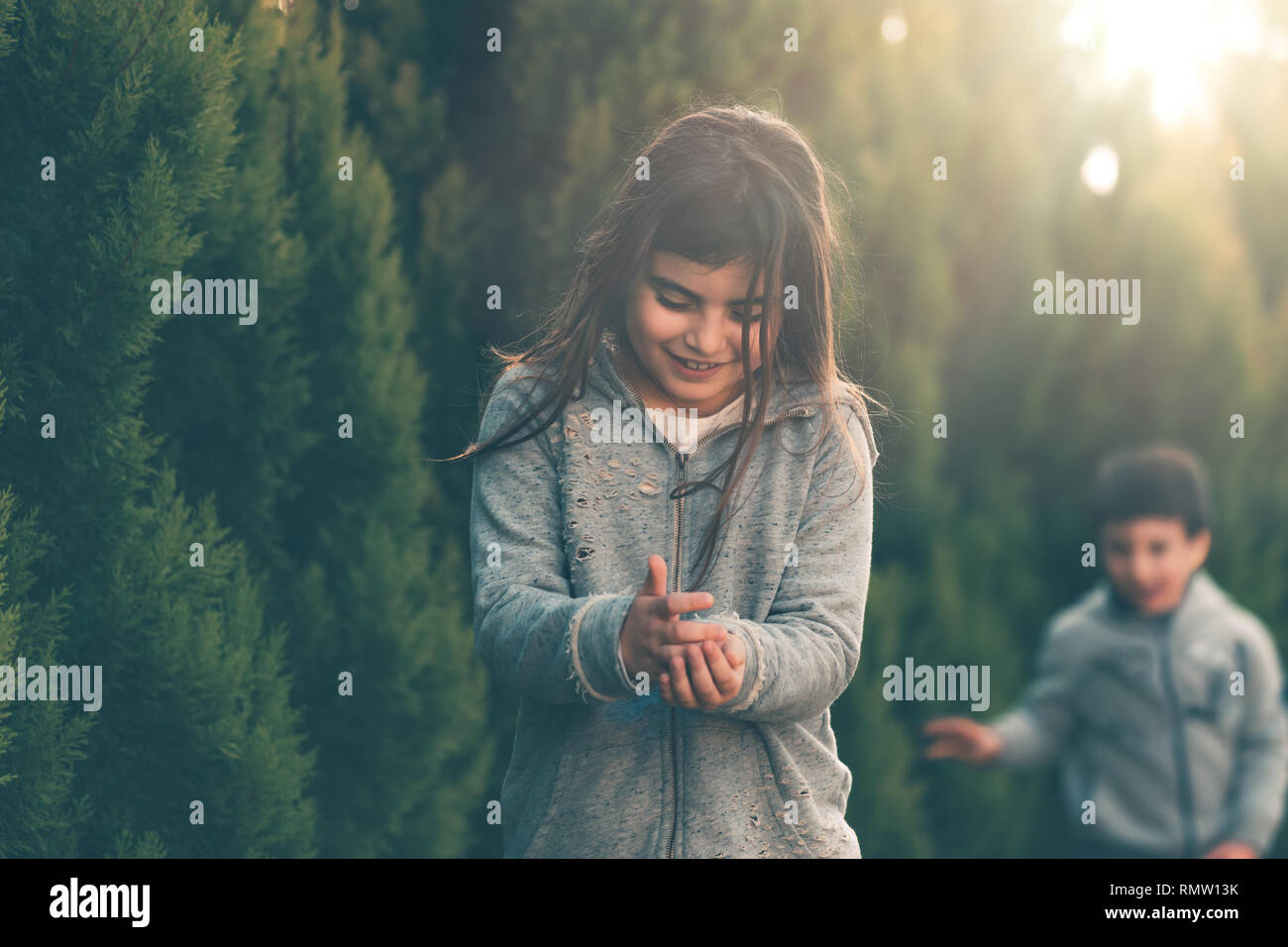 Happy friends hunting on eggs in the park in sunny day, brother and ...