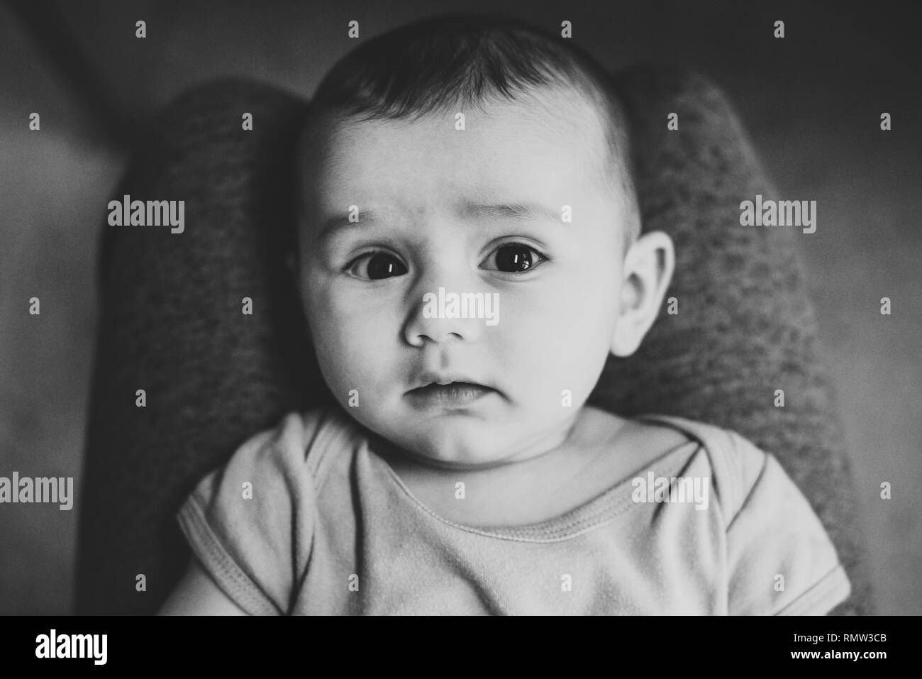Portrait of the round face of a baby on his mother's legs Stock Photo ...
