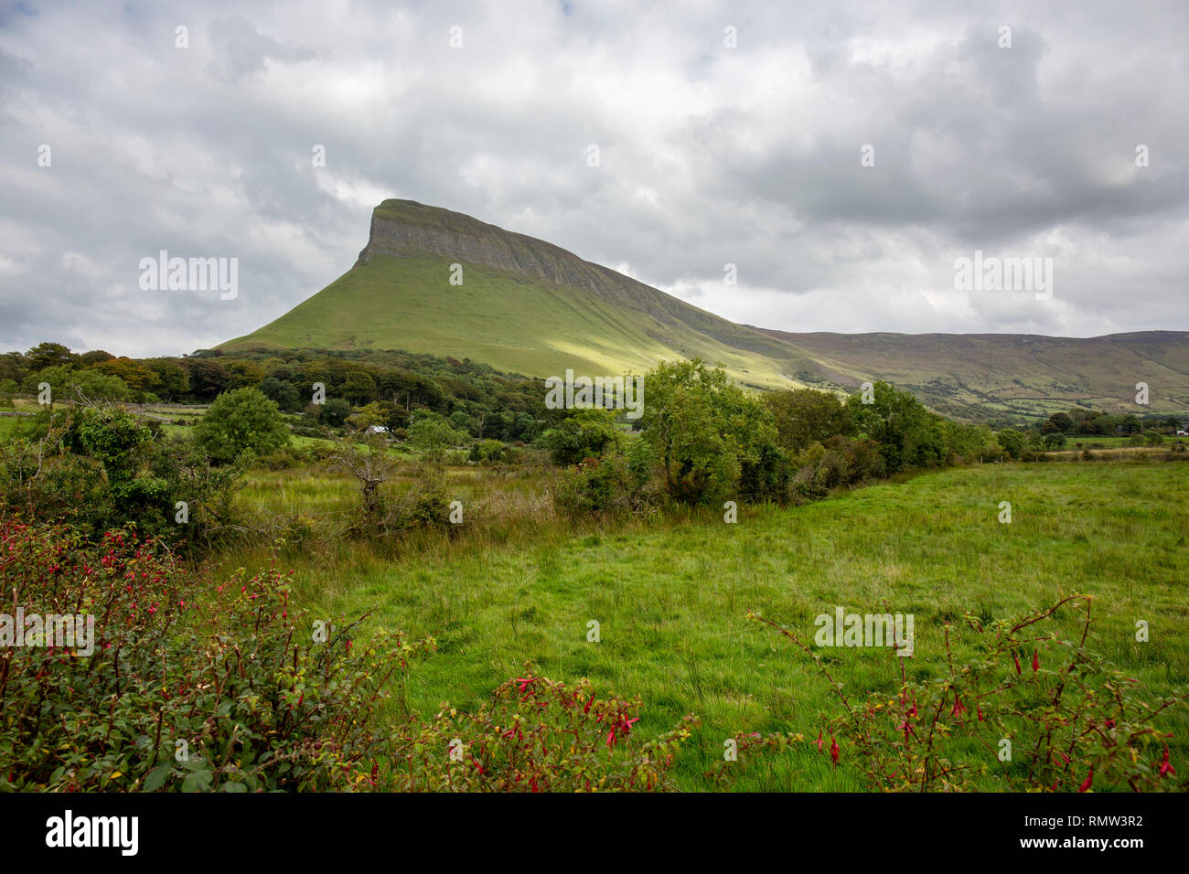 Typical Irish landscape with dark grey clouds, rain and mountains ...