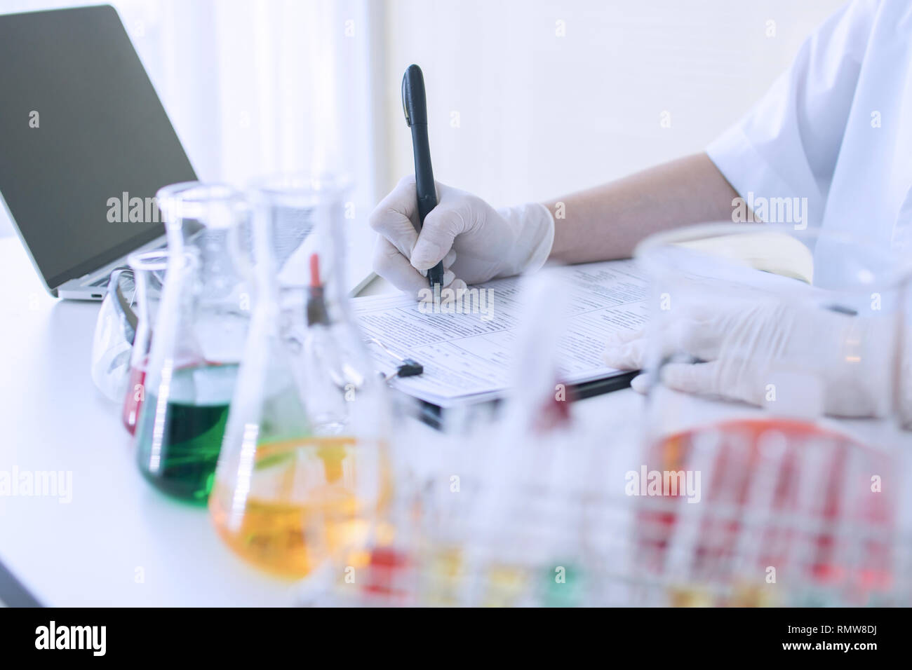 scientist experiment chemical liquid and writing information on paper ...