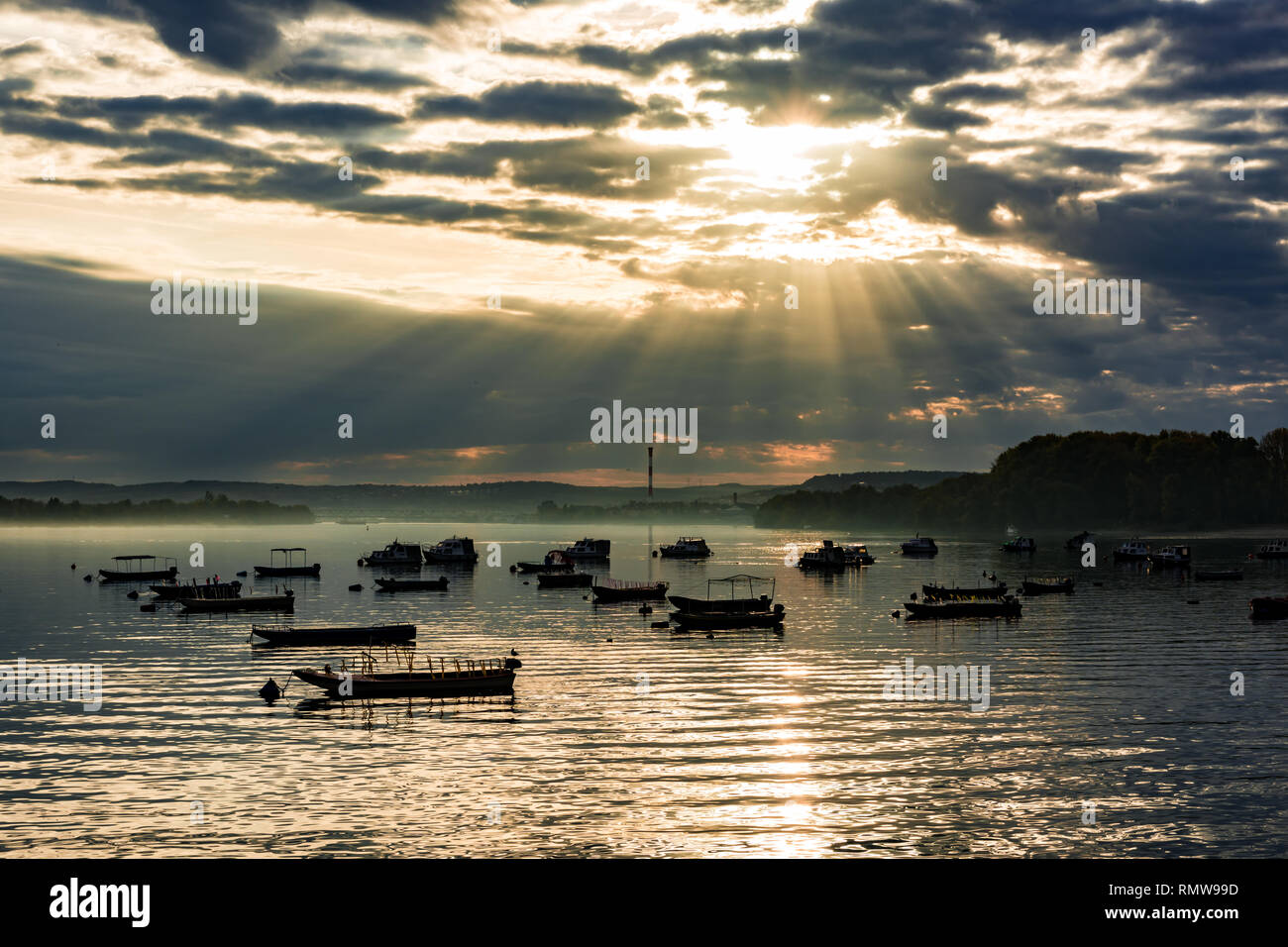 The morning sun's rays that pierce through the clouds, illuminate the ...