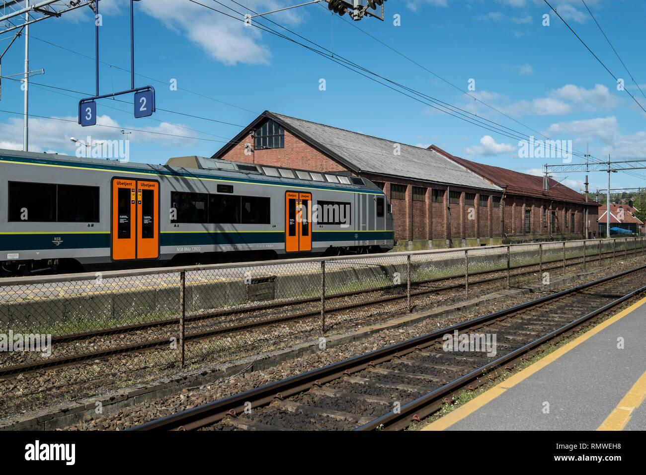 A commuter train waits at a station in Moss, about an hour south of ...