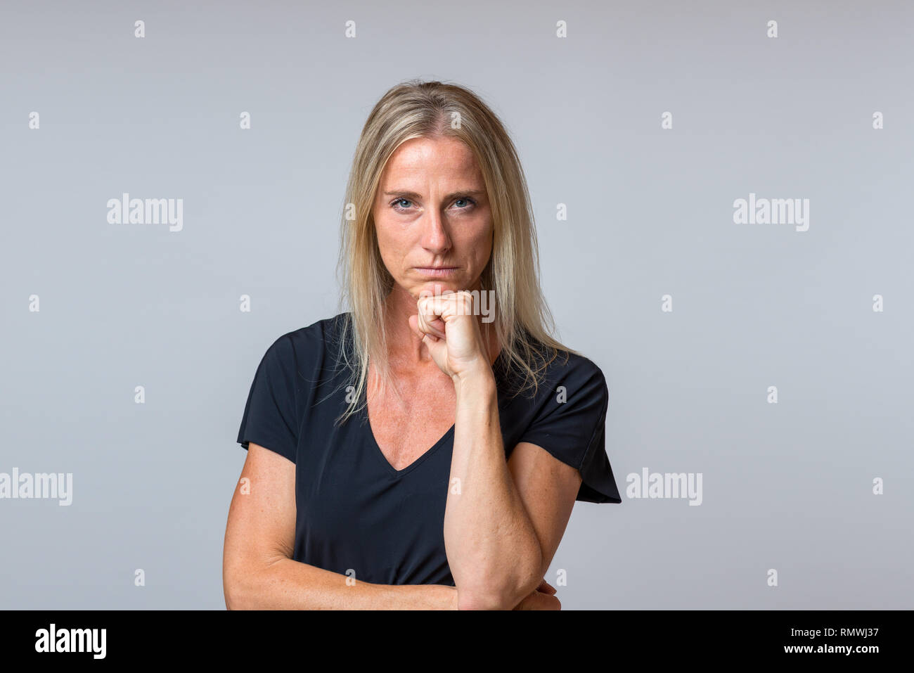 Determined focused middle-aged blond woman staring intently at the ...