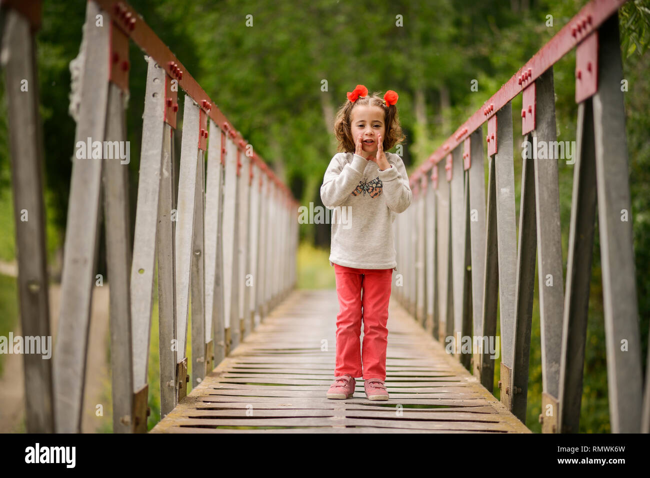 Cute little girl having fun in a rural bridge Stock Photo - Alamy