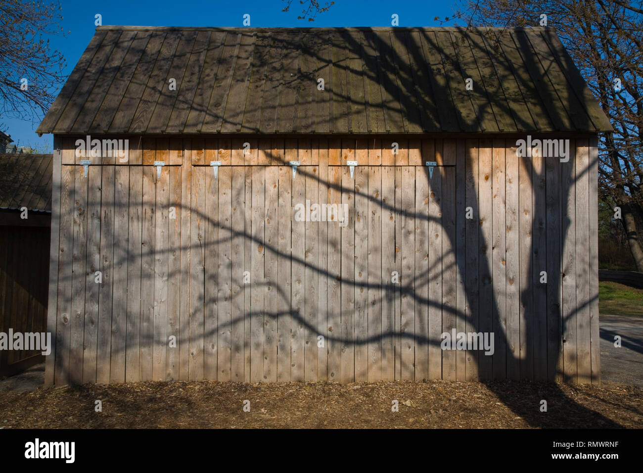 Tree shadows on rustic wooden storage shed, Ile des Moulins, Old ... Tree shadows on rustic wooden storage shed, Ile des Moulins, Old ...