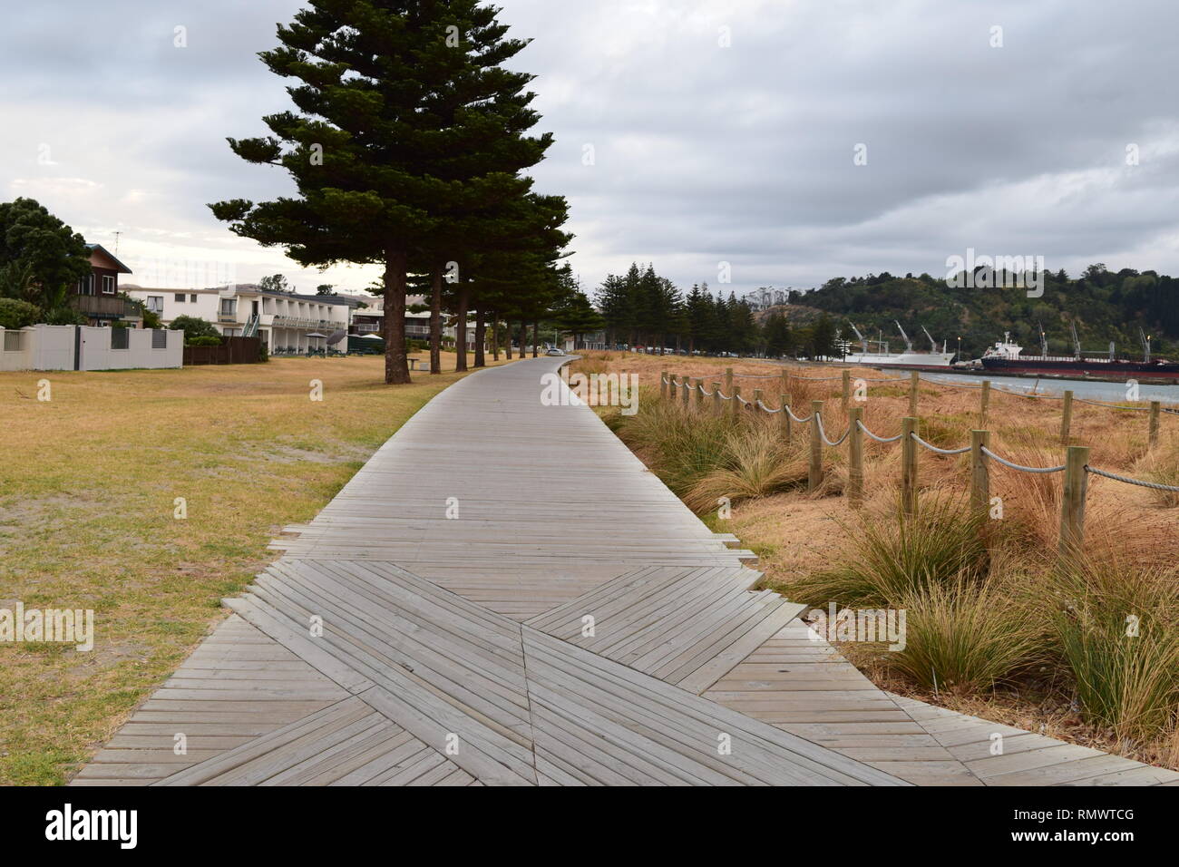 A timber path lines the beach during Summer in Gisborne, New Zealand ...