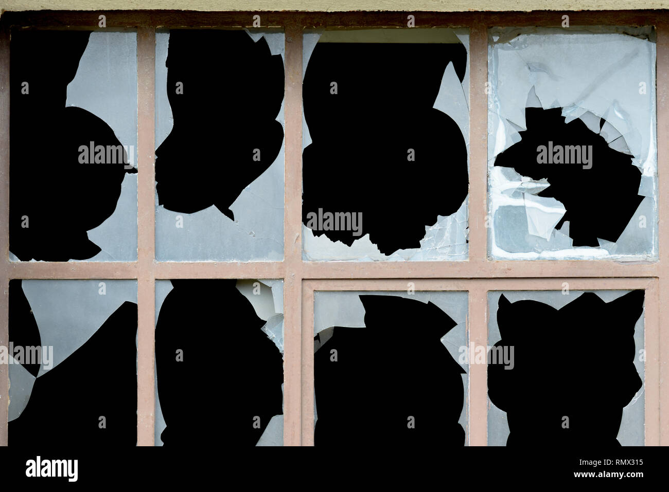 Old window with broken panes of opaque white glass with jagged edges ...