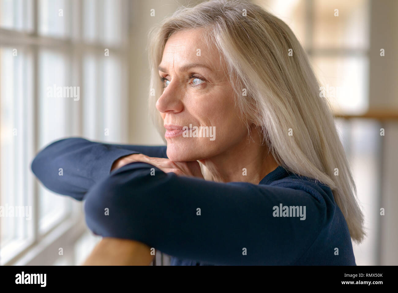 Attractive woman with cheerful expression standing with her hand to her ...