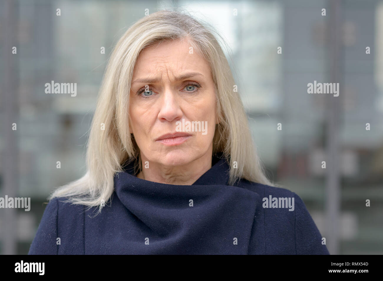 Puzzled troubled attractive middle-aged woman standing in an urban ...