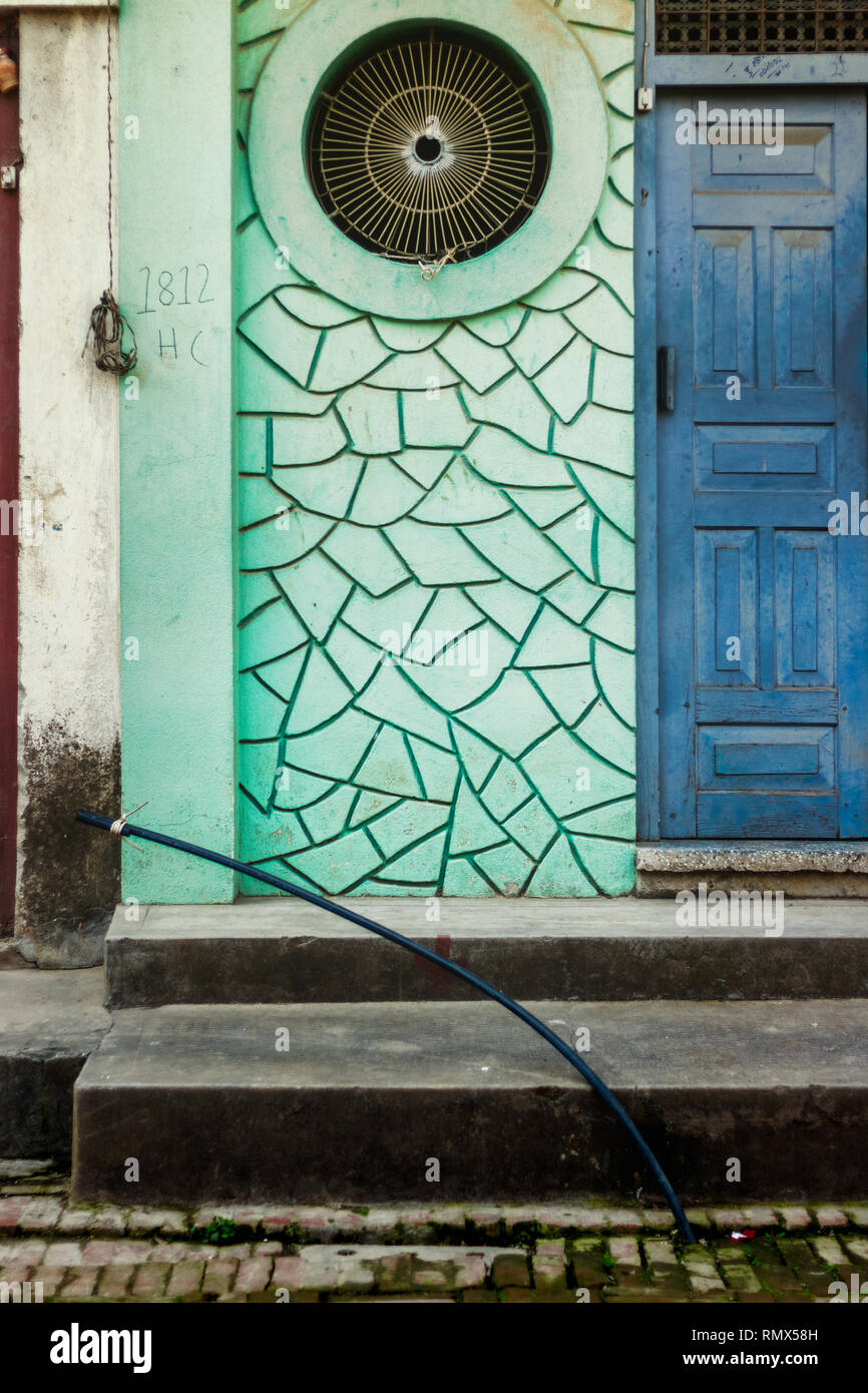 An earthing wire pipe extension in front of a textured wall and a door ...