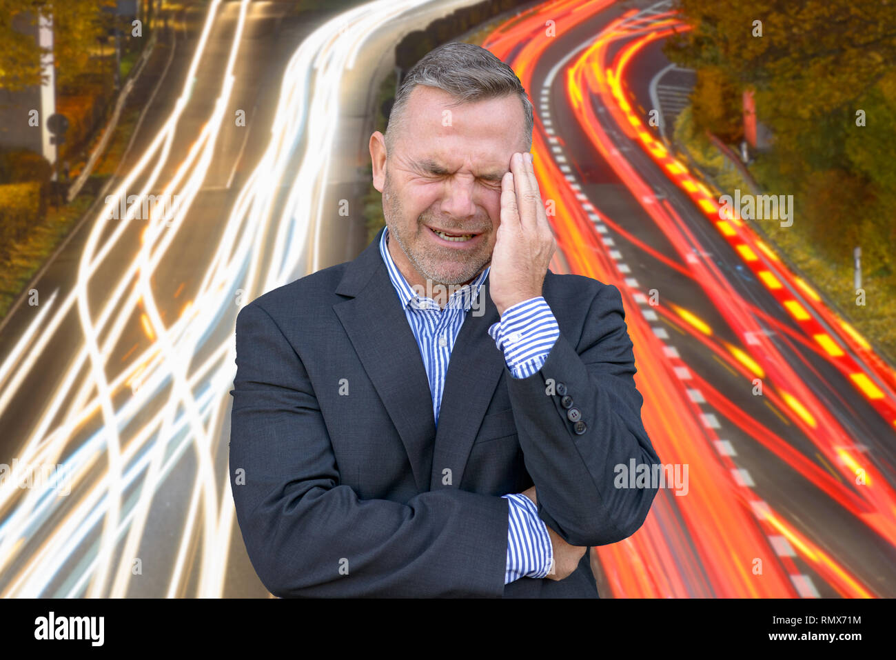 Stressed businessman, or suffering from a headache, standing with his ...
