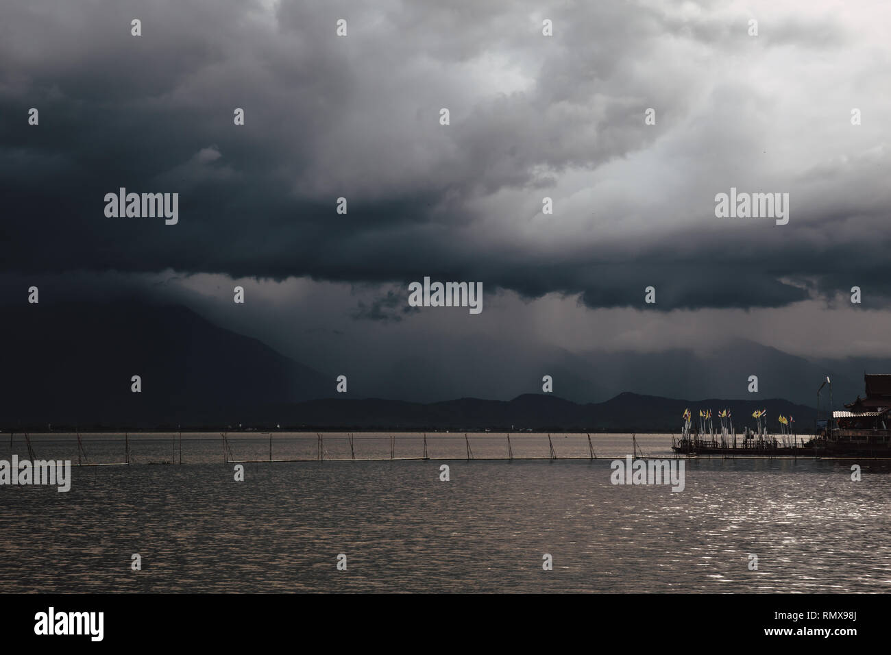 heavy rain storm dark cloud over lake mountain dramatic nature background Stock Photo - Alamy