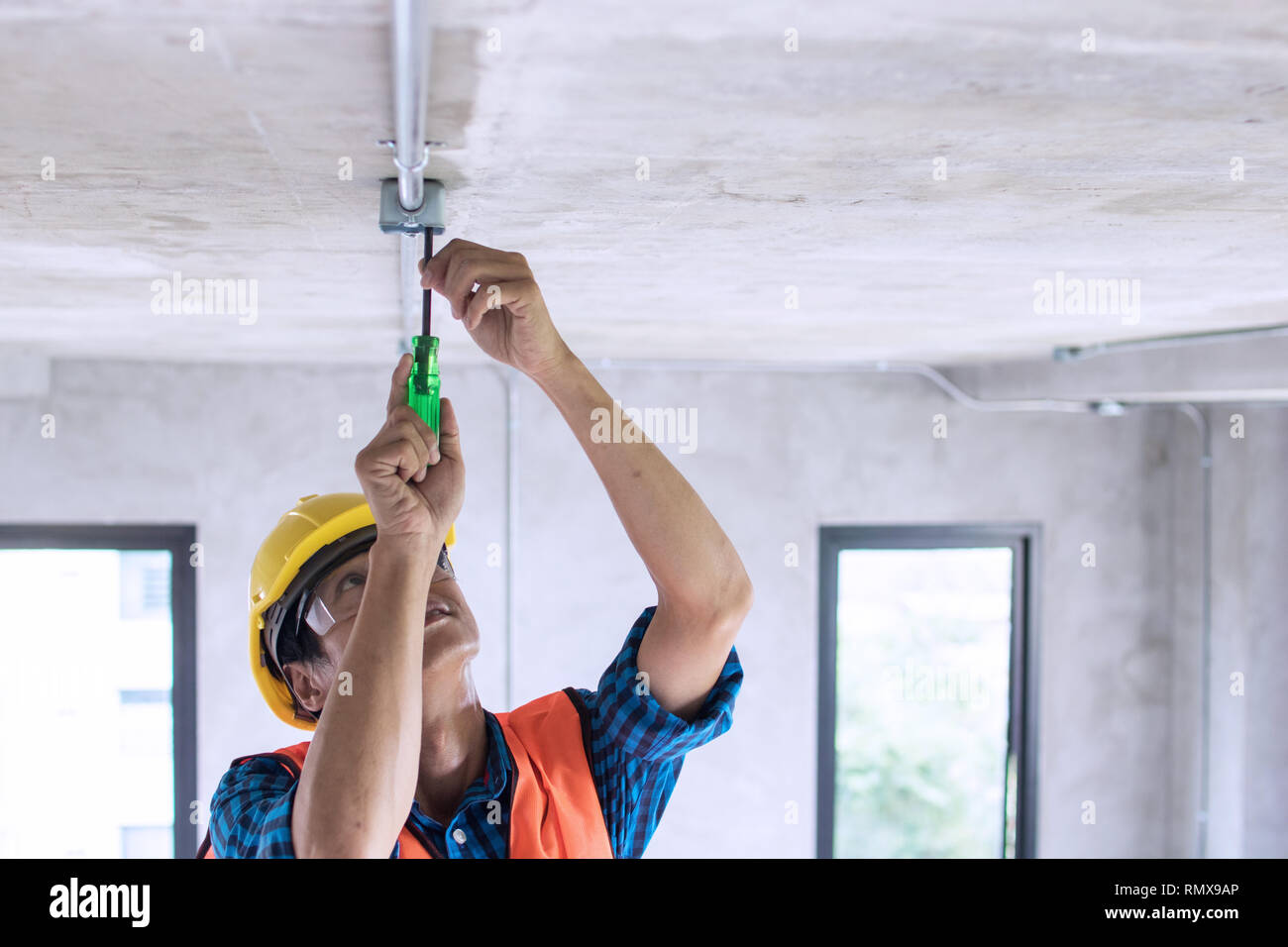 Electrician wiring on ceiling in construction site Stock Photo - Alamy
