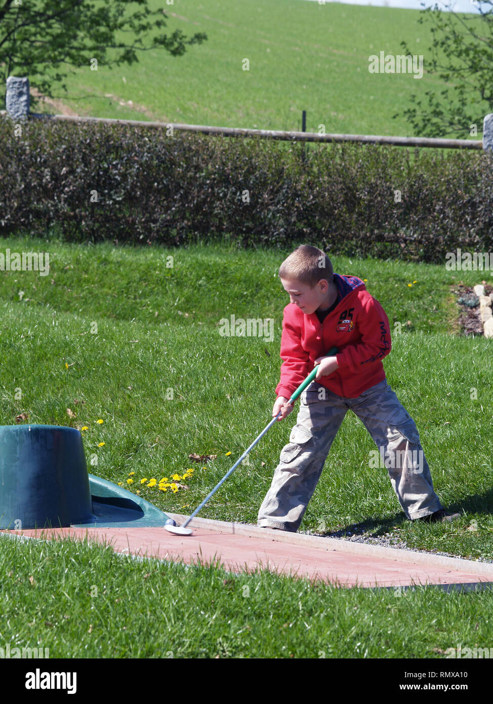 Little boy playing golf on vacation Stock Photo - Alamy