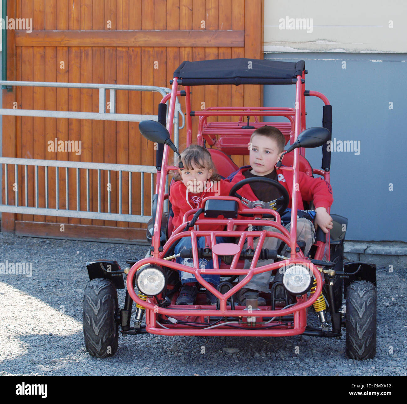 Boy explaining to his little sister how to ride buggy Stock Photo - Alamy