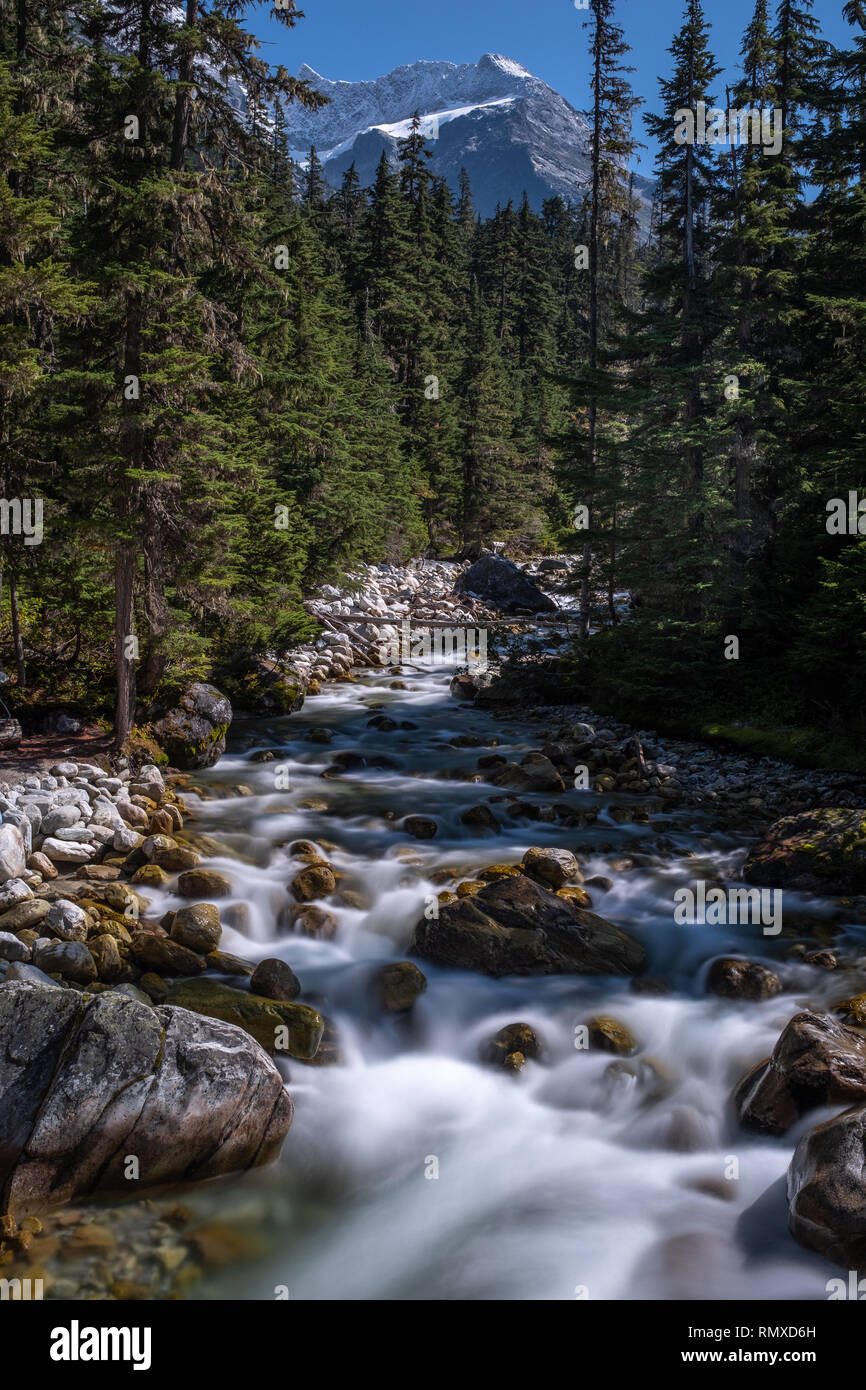 A river in Canada cascading through rocks, in the background is a snow ...