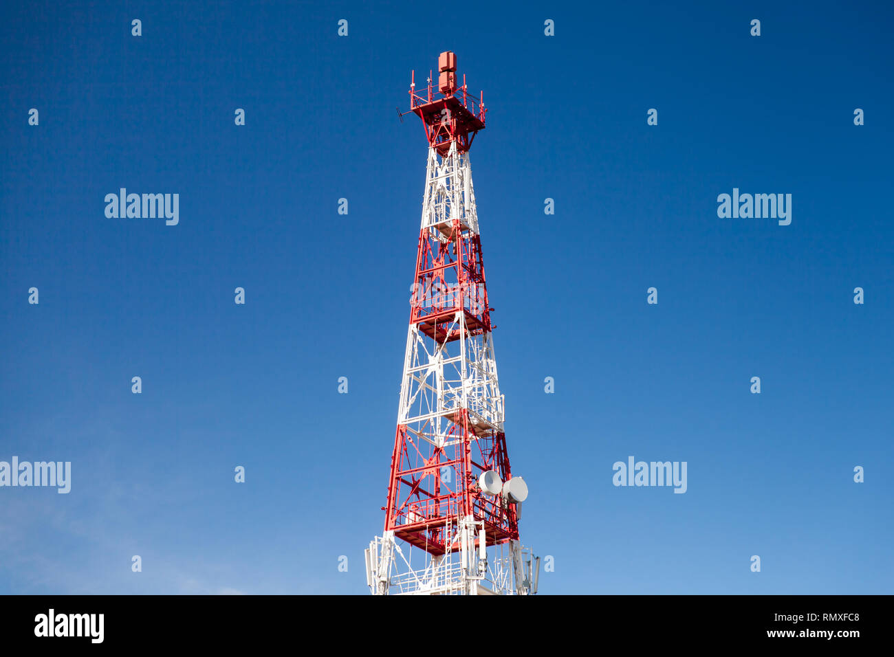 Red white telecommunication tower with radio devices over blue sky background Stock Photo - Alamy