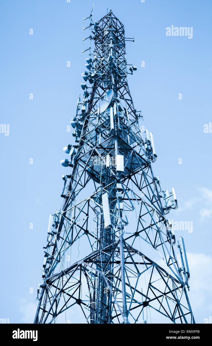 Telecommunication tower with radio devices, blue toned vertical photo ...