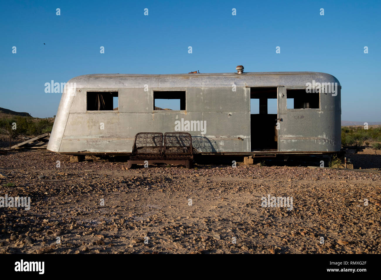 An old, abandoned and wrecked vintage Airstream trailer with a rusted ...