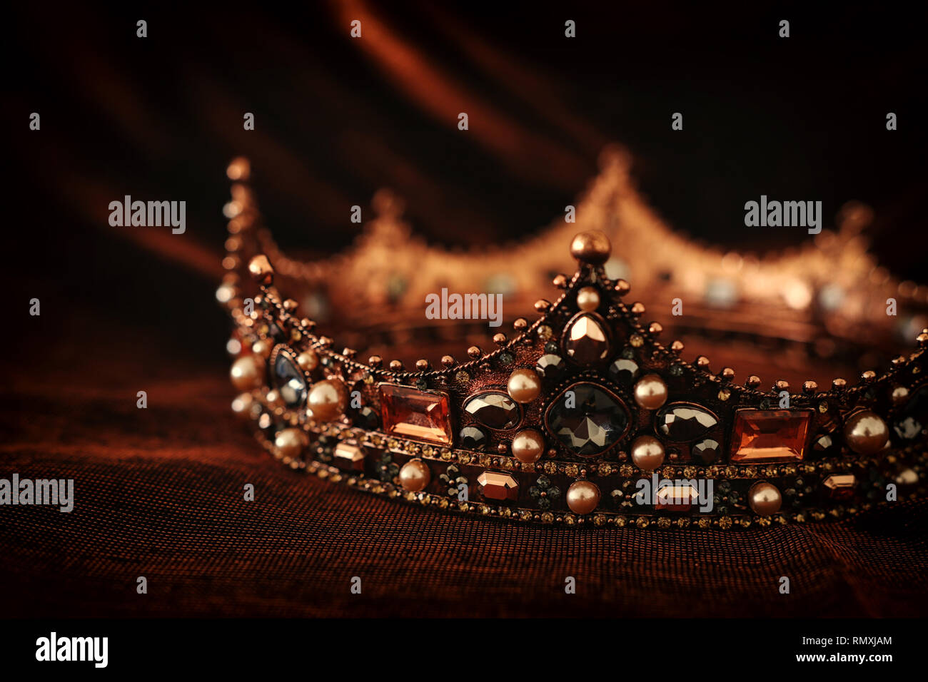 photo of gold crown over gothic dark silk background. Medieval period ...