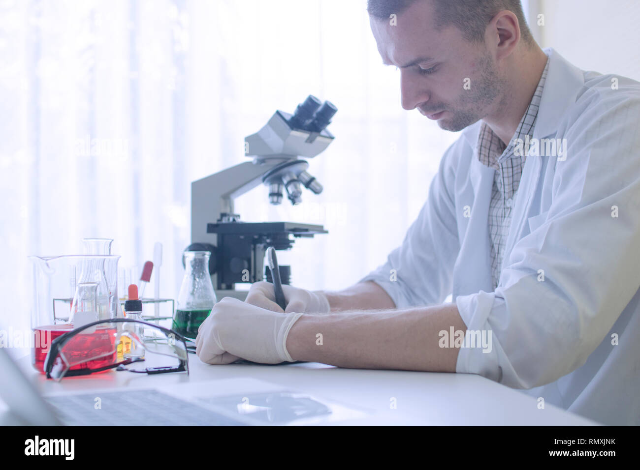 scientist experiment chemical liquid and writing information on paper ...