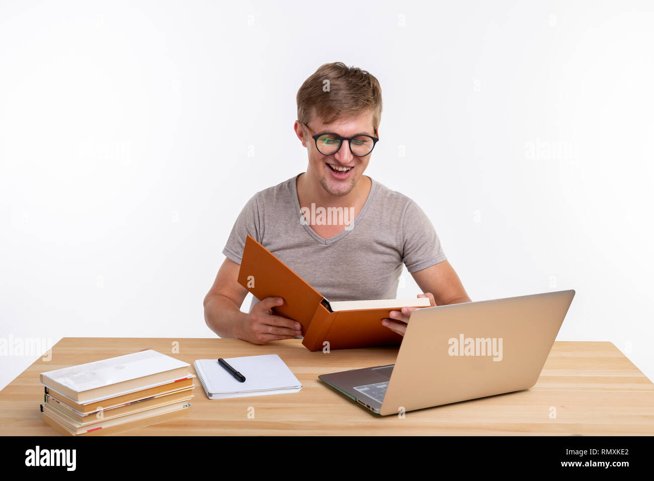 People and education concept - Handsome male student reading a textbook ...