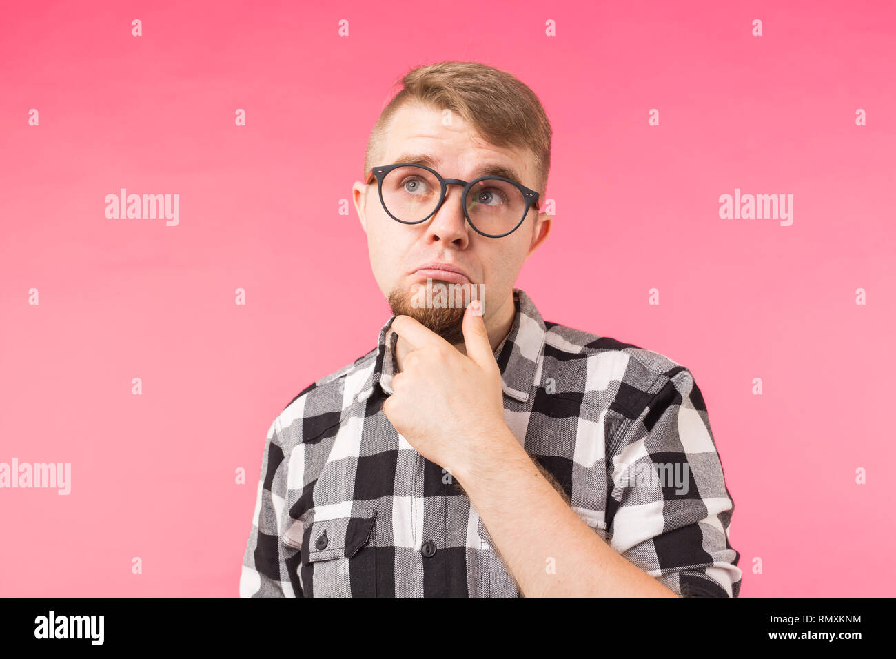 Geek, education, people concept - Thoughtful young man over the pink ...