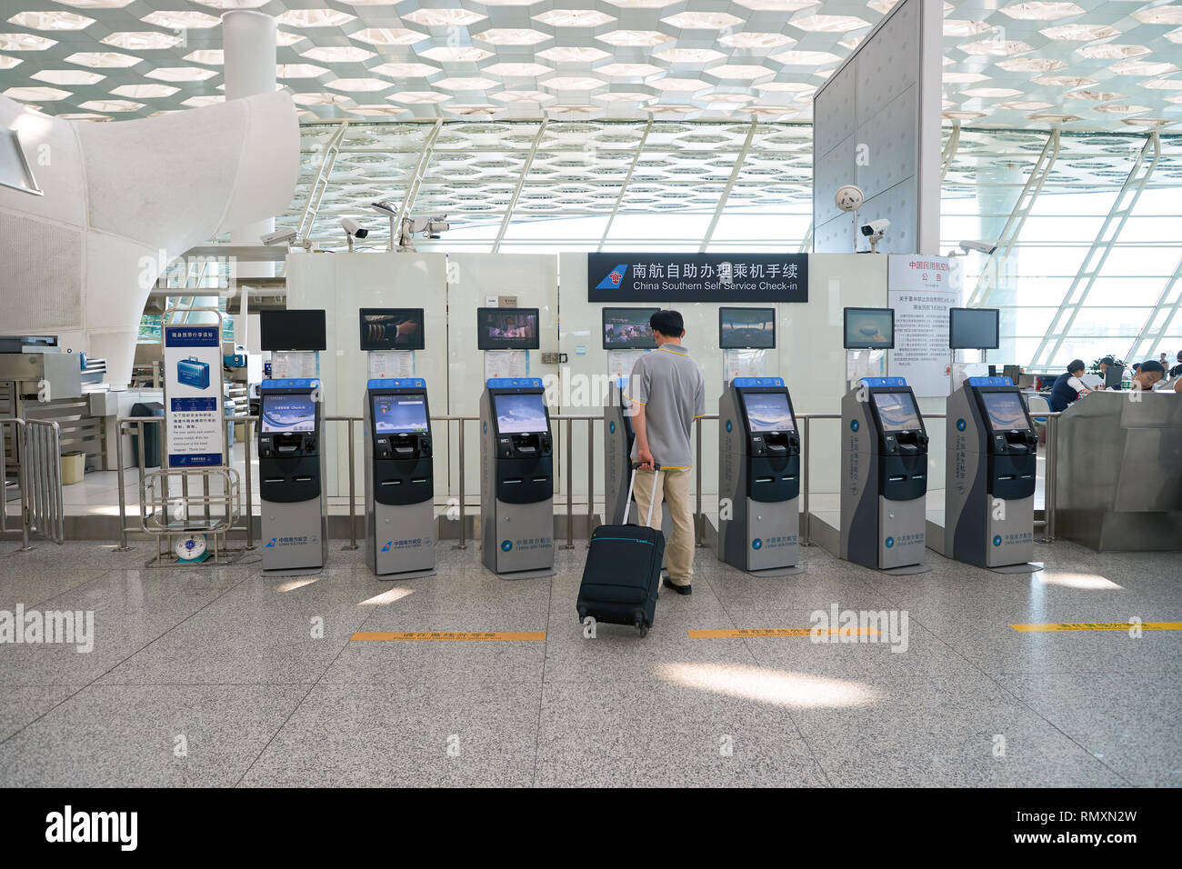 SHENZHEN, CHINA - CIRCA MAY, 2016: man use self check-in kiosk in ...