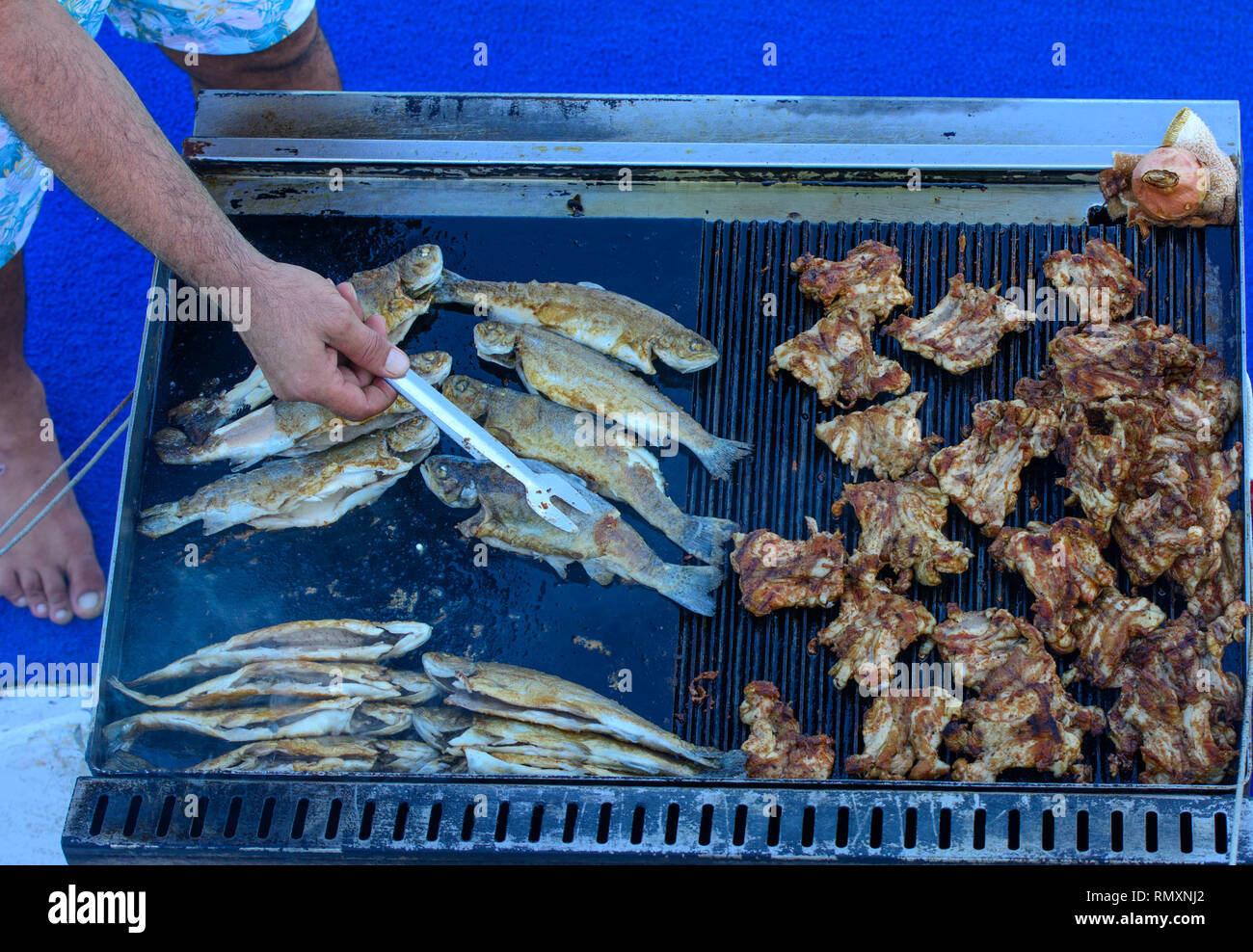 Beautifully cooked fried pieces of quail meat and whole trout fish on ...