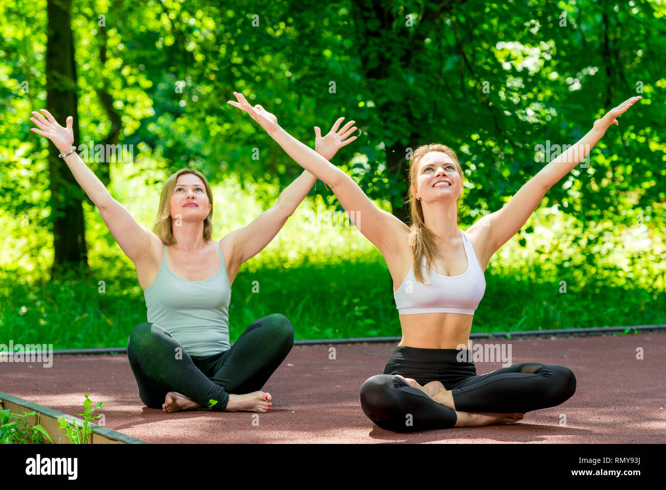 happy active women outdoors in lotus position doing yoga Stock Photo ...