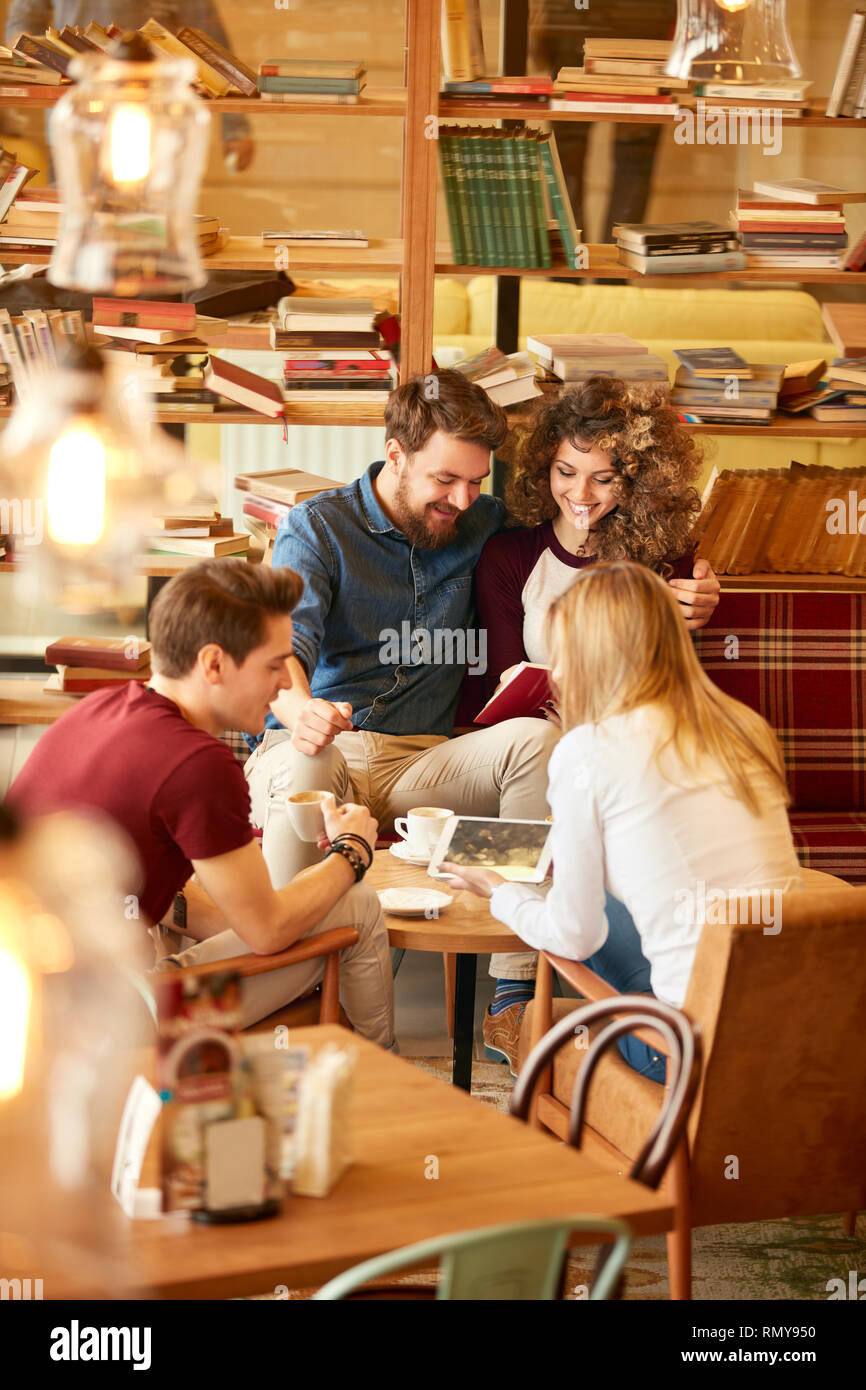 Two couple enjoying in chat and coffee in library Stock Photo - Alamy