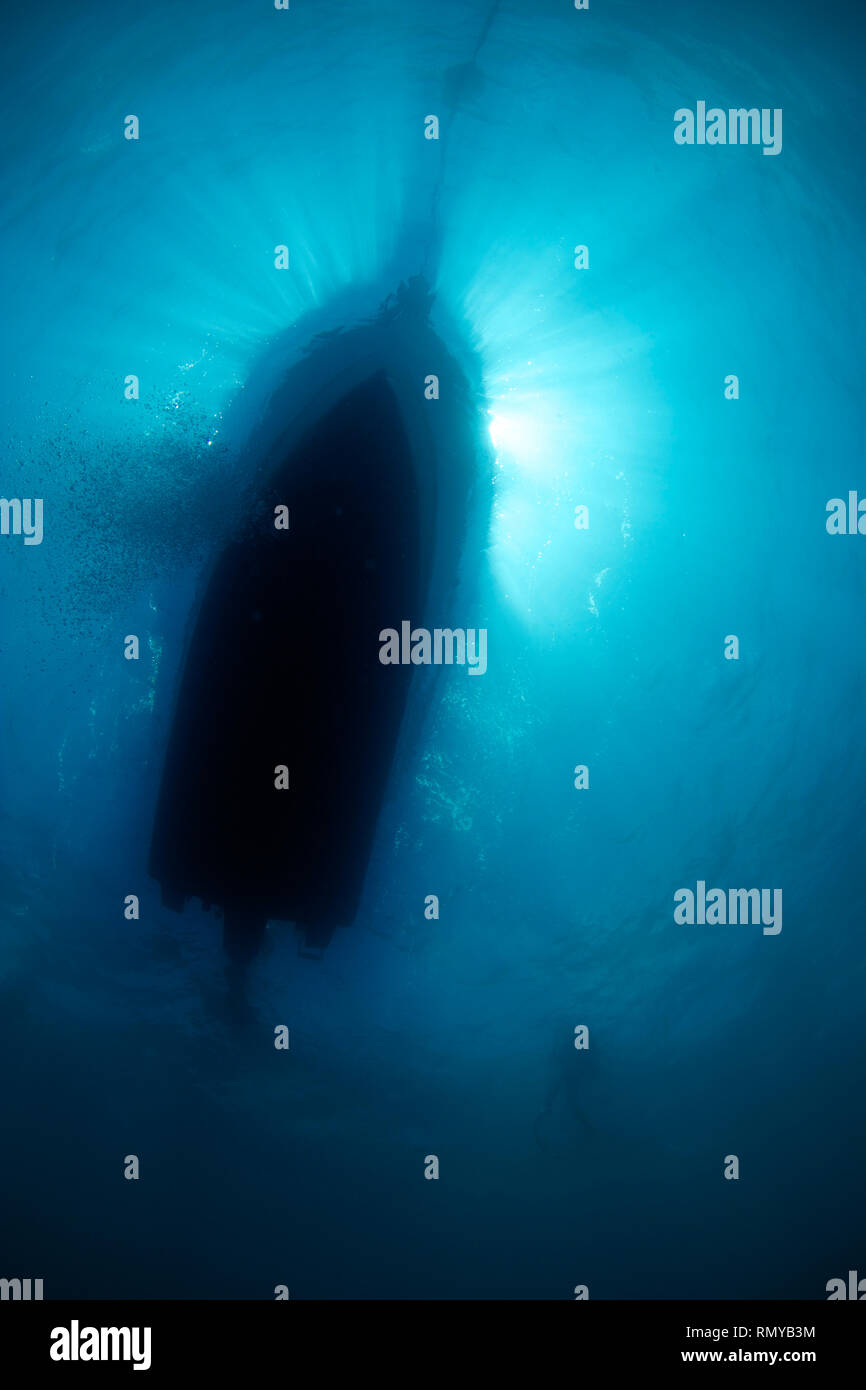 The hull of a boat from underwater, in crystal clear azure blue ocean ...