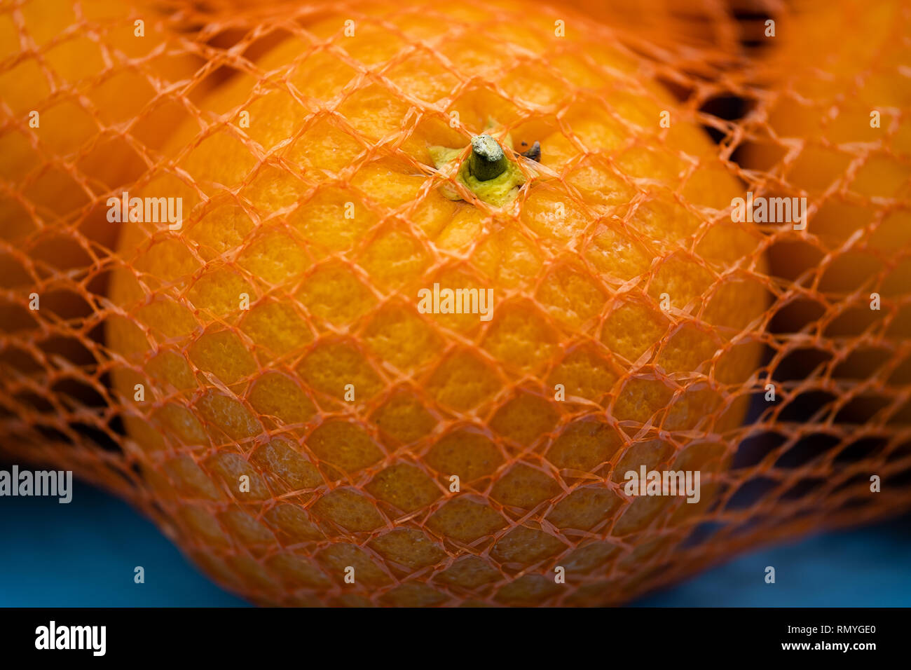 Orange in the packaging net Stock Photo - Alamy