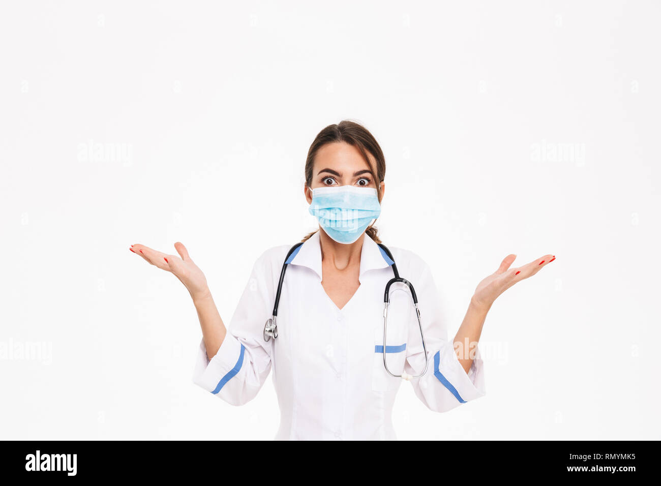 Confused young woman doctor wearing uniform standing isolated over ...