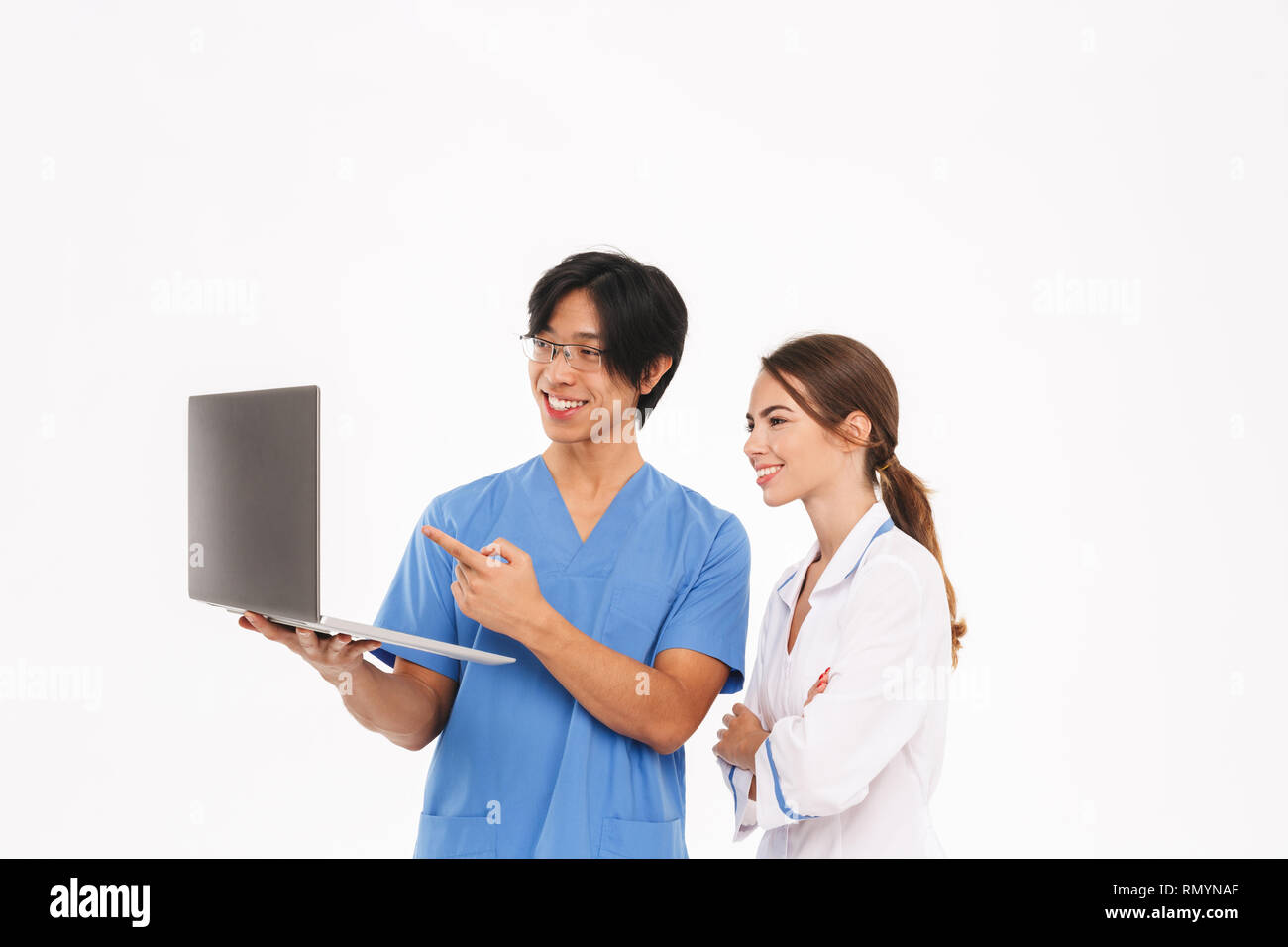 Smiling doctors couple wearing uniform standing isolated over white ...