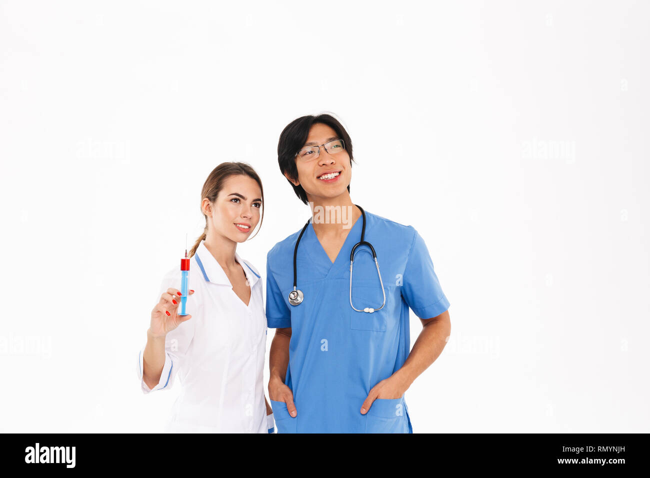 Smiling doctors couple wearing uniform standing isolated over white ...